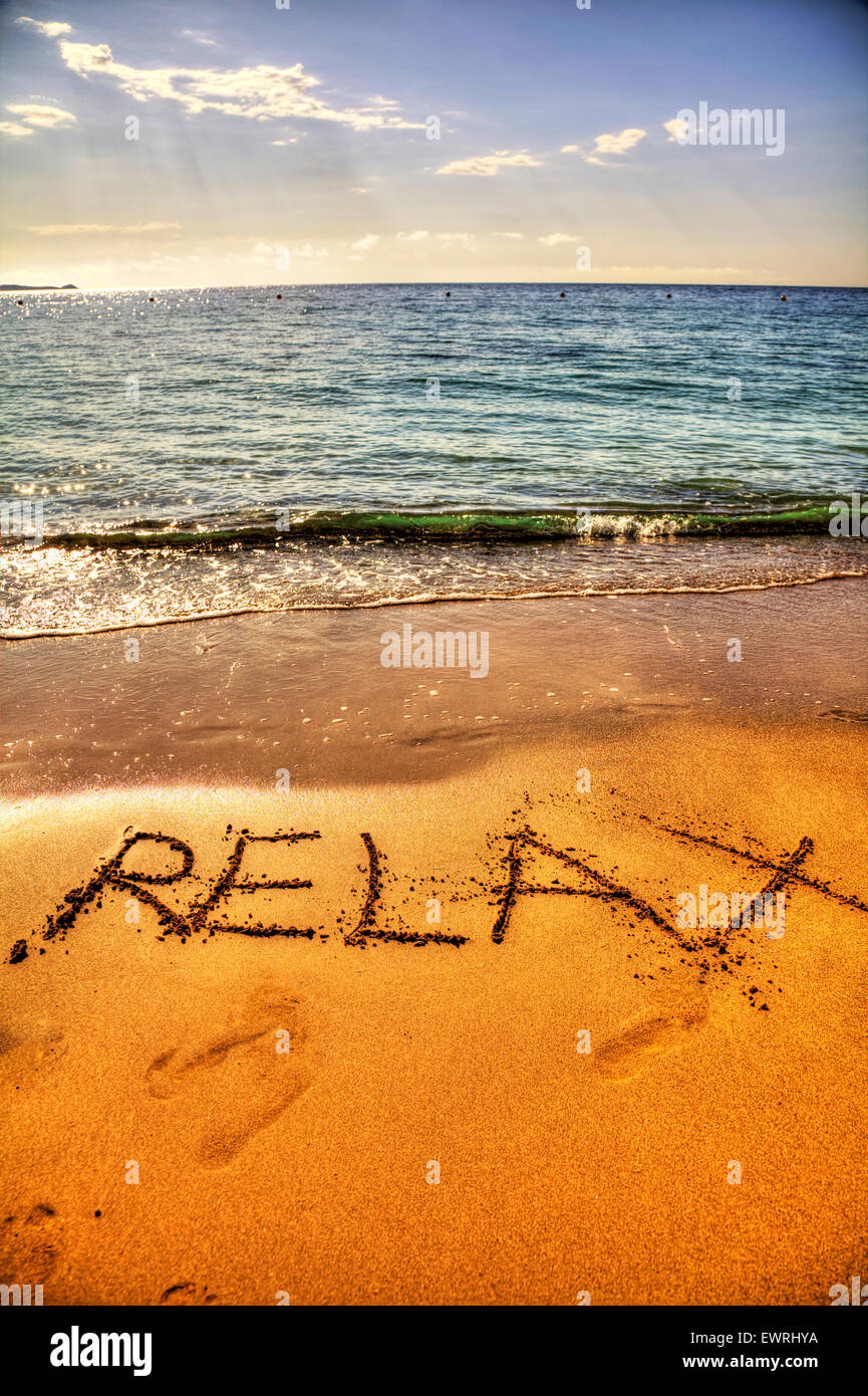 Word relax written in sand beach hi-res stock photography and images ...