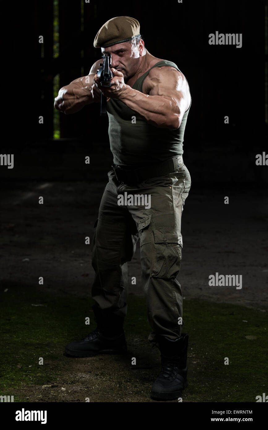 Action Hero Muscled Man Holding Machine Gun - Standing In Abandoned ...