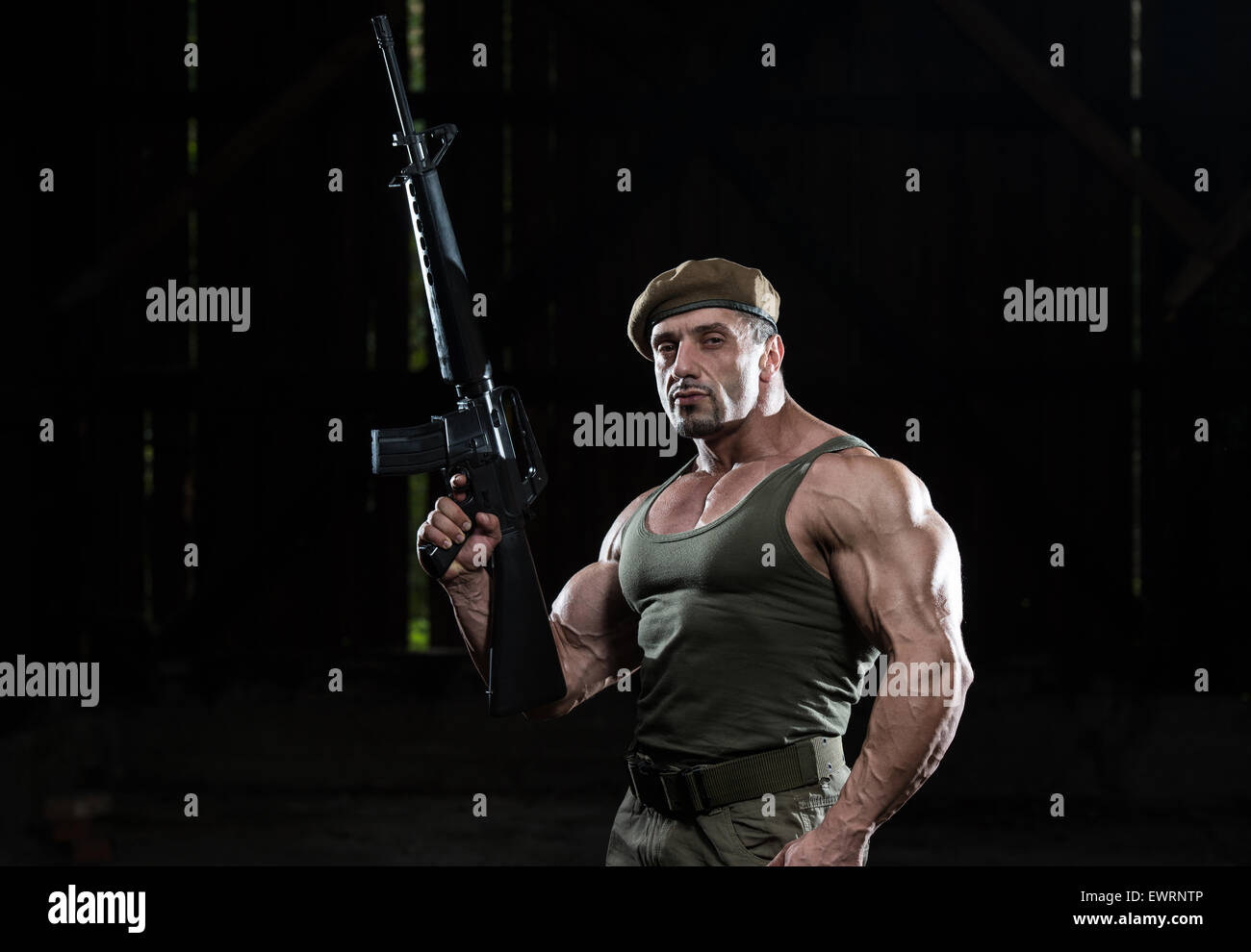 Action Hero Muscled Man Holding Machine Gun - Standing In Abandoned ...