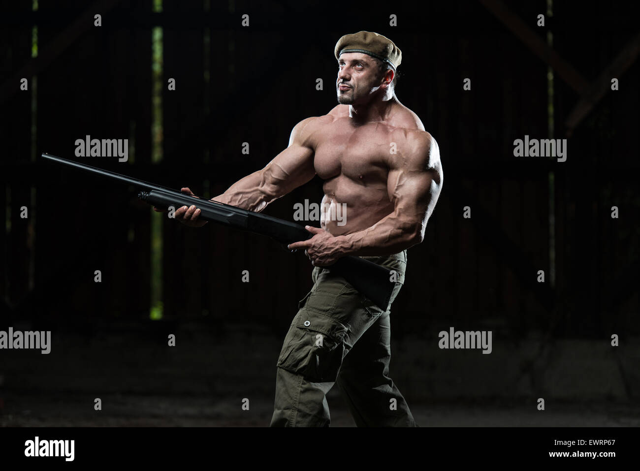 Action Hero Muscled Man Holding Machine Gun - Standing In Abandoned ...