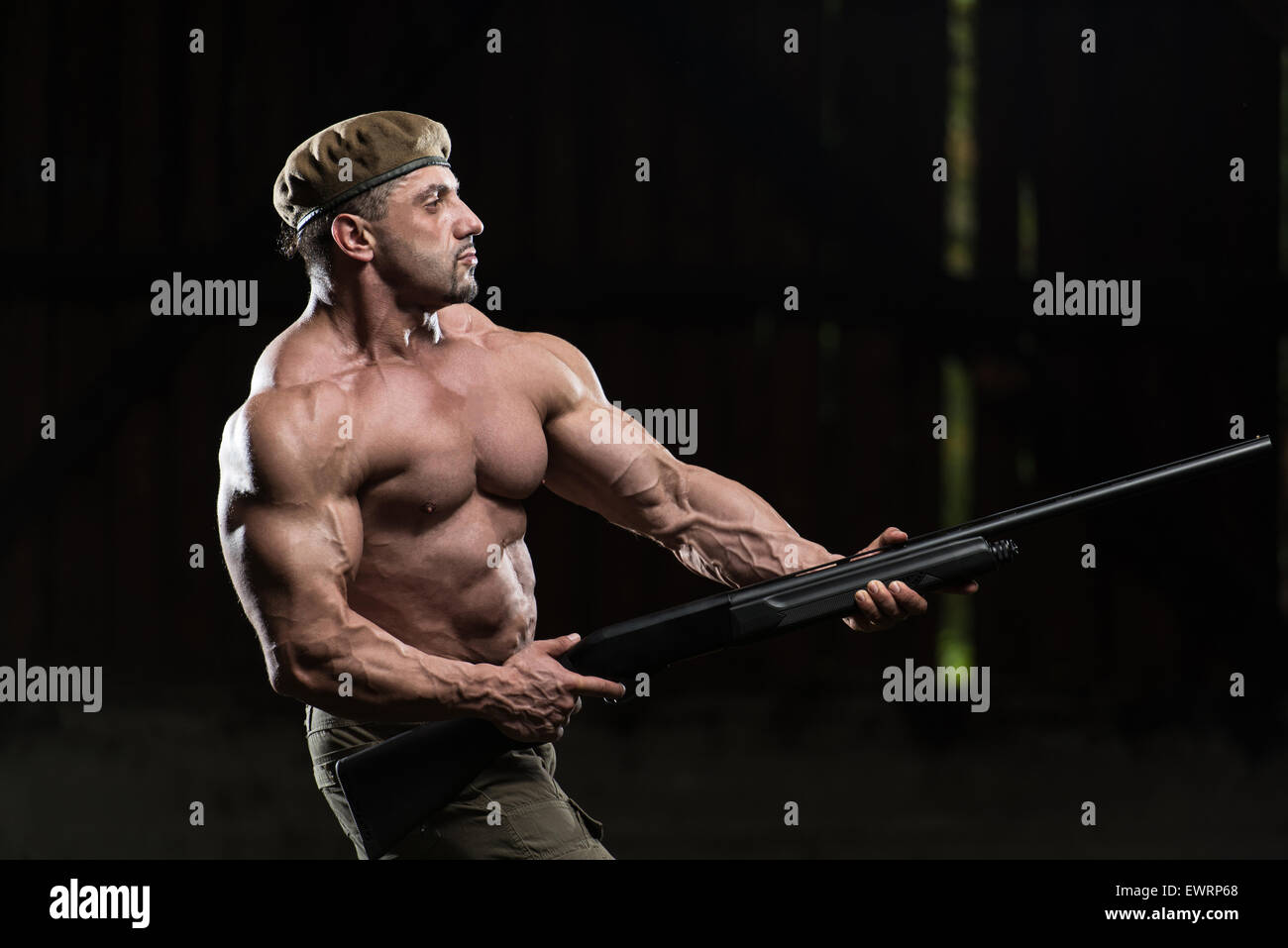 Action Hero Muscled Man Holding Machine Gun - Standing In Abandoned ...