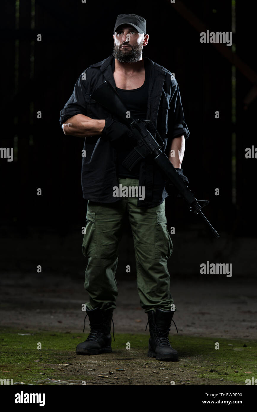 Action Hero Muscled Man Holding Machine Gun - Standing In Abandoned ...