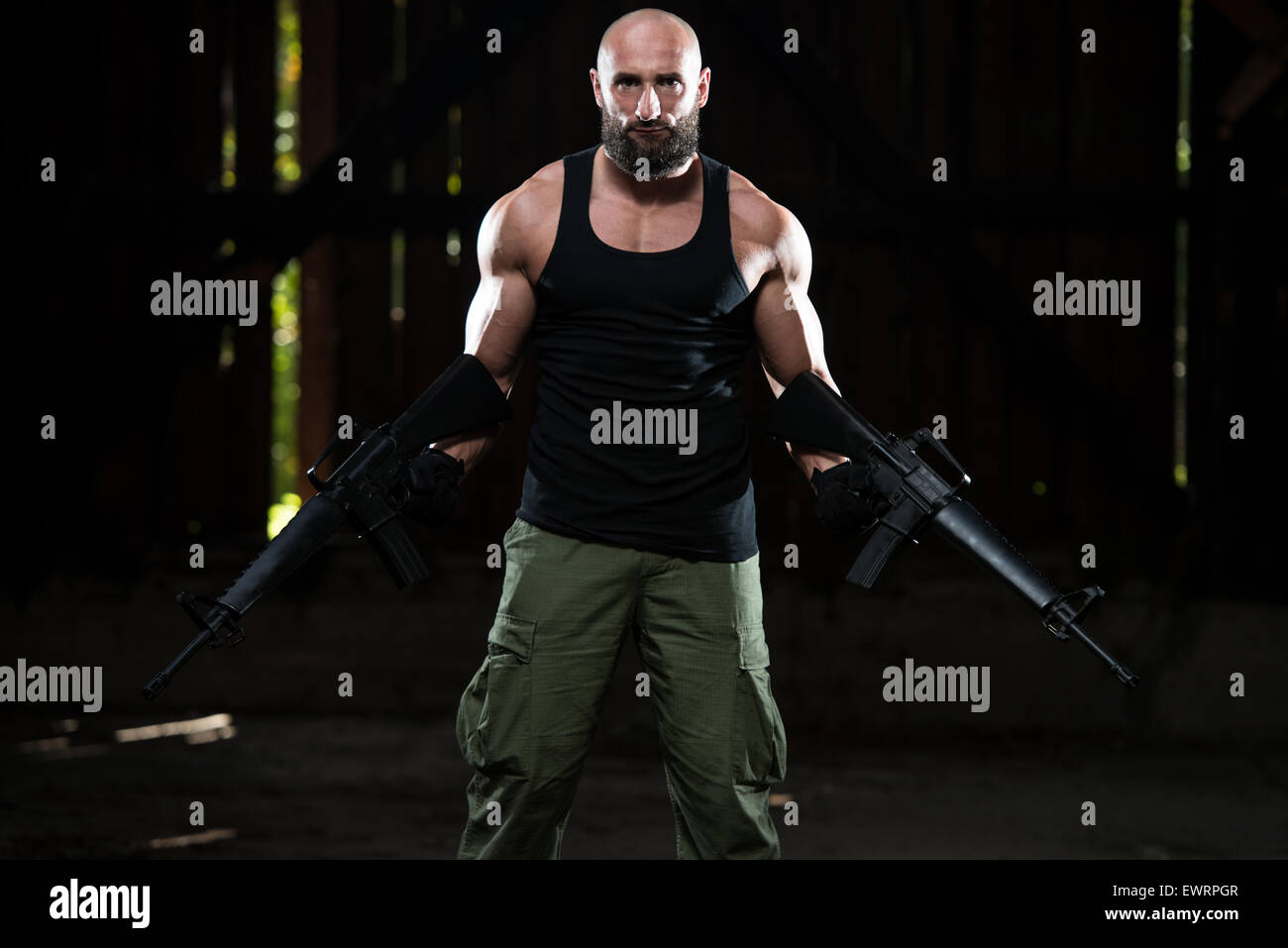 Action Hero Muscled Man Holding Machine Gun - Standing In Abandoned ...