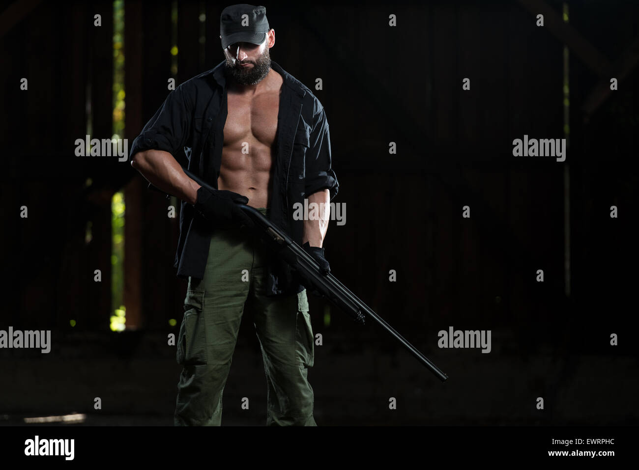Action Hero Muscled Man Holding Machine Gun - Standing In Abandoned ...