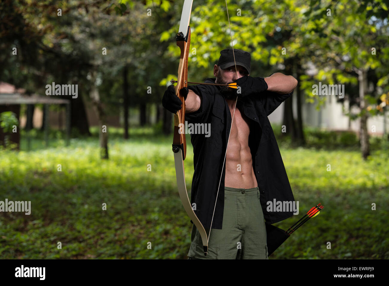 Beard Man With A Bow And Arrows In The Woods Stock Photo - Alamy
