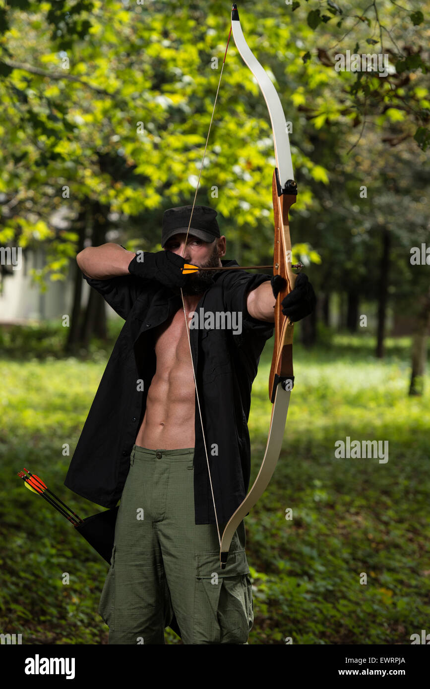 Beard Man With A Bow And Arrows In The Woods Stock Photo - Alamy