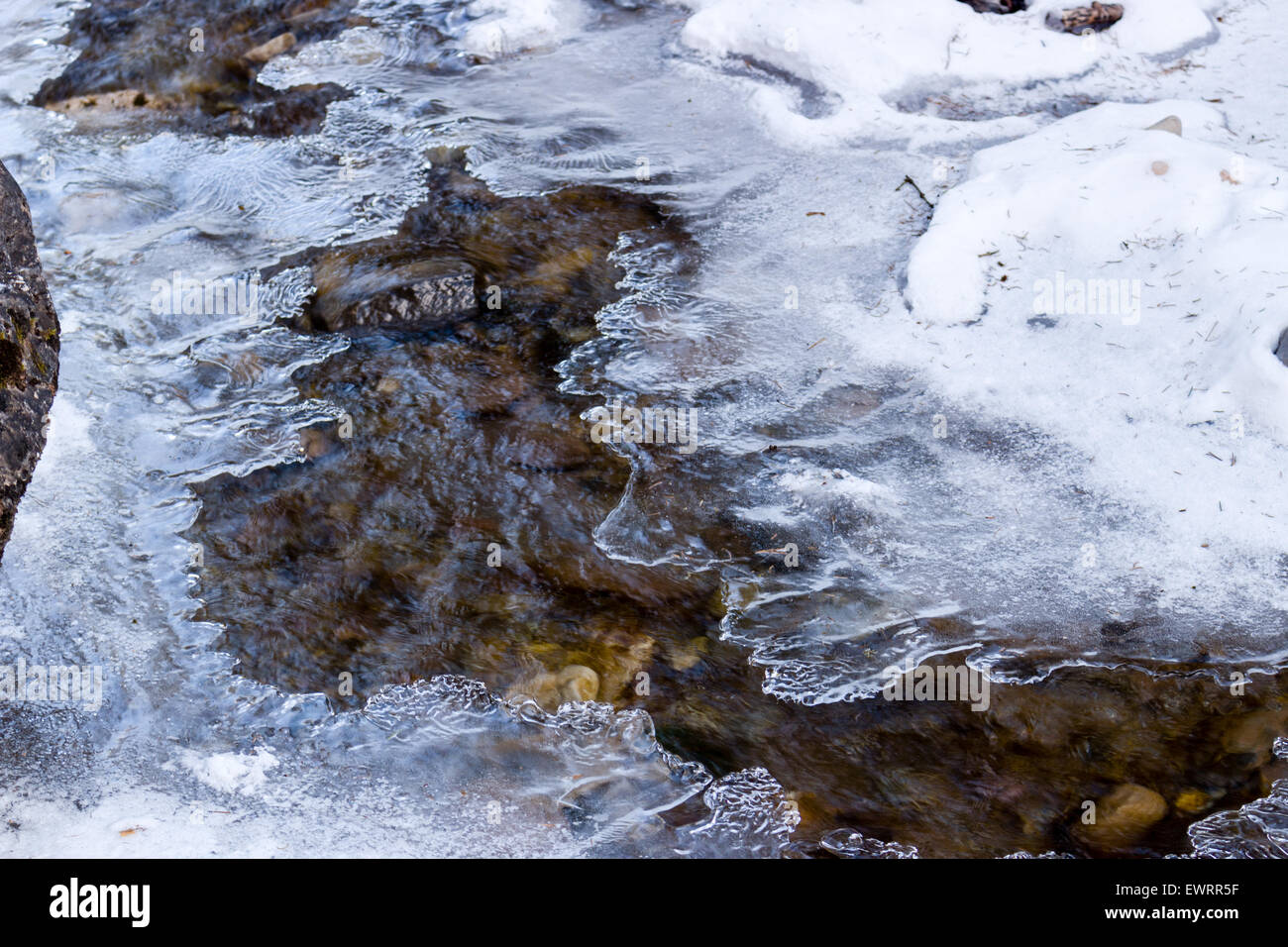 frozen mountain stream in the middle of ice, snow and rocks Stock Photo ...