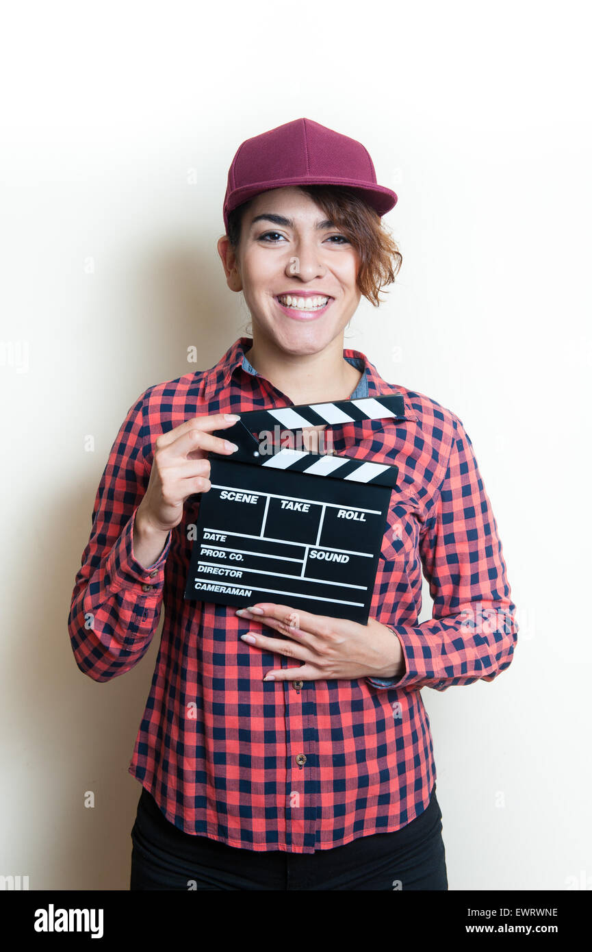 Girl in red shirt and cap smiling and showing movie clapper on white ...