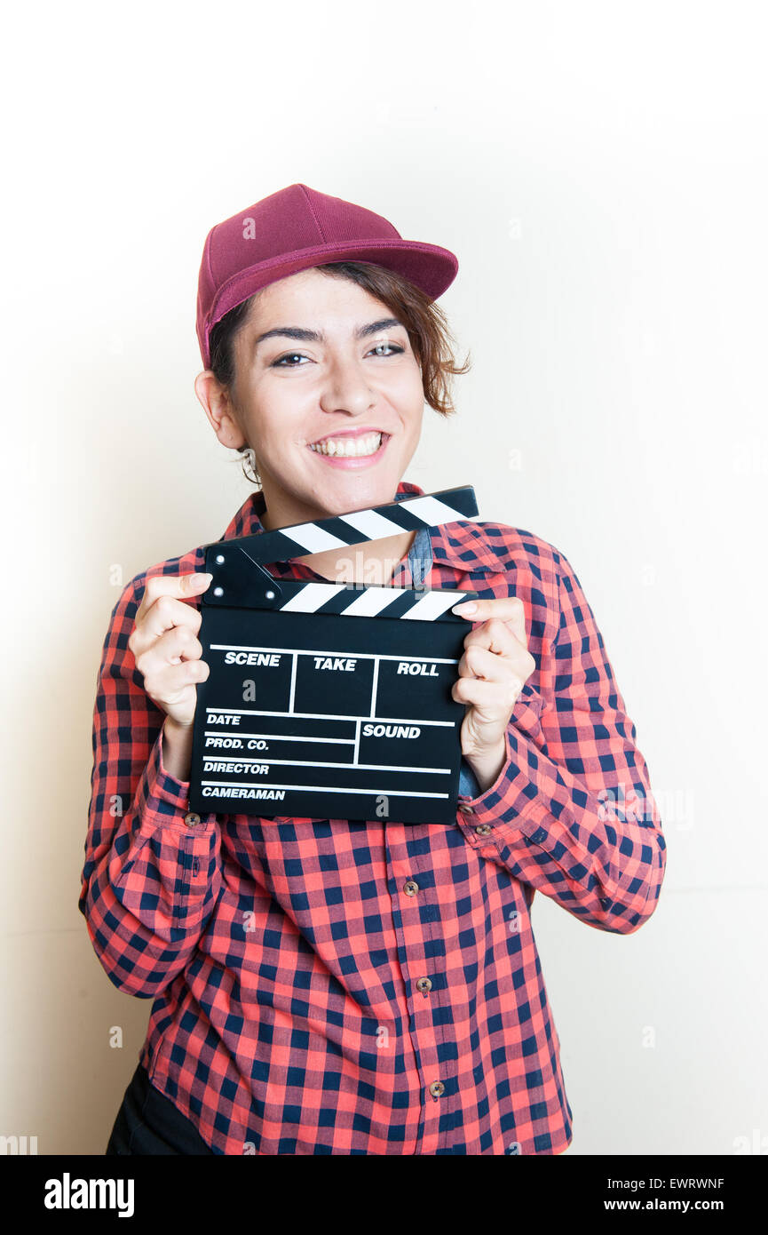 Girl in red shirt and cap smiling and showing movie clapper on white ...