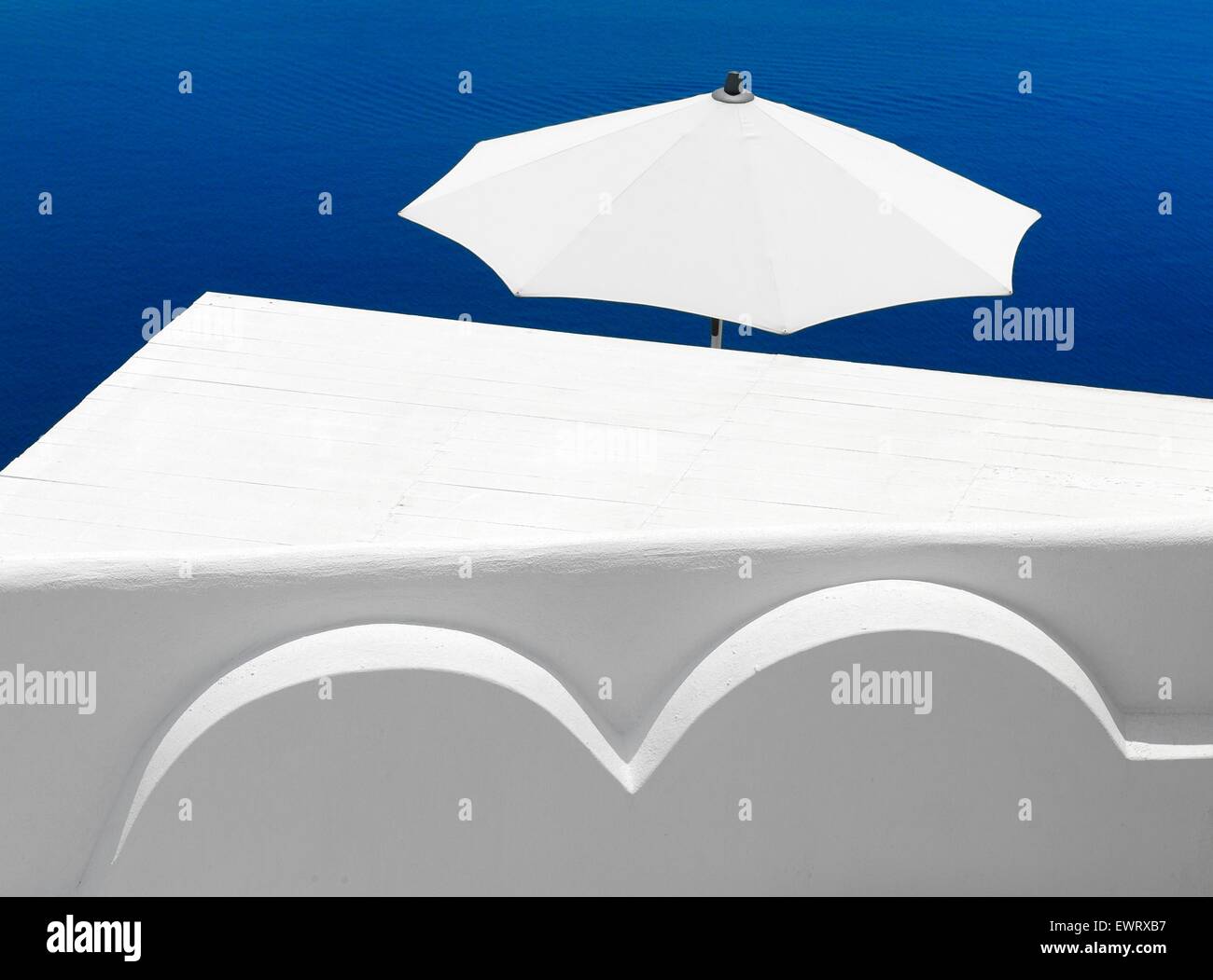 A whitewashed building and sun brolly on the Island of Santorini Greece ...