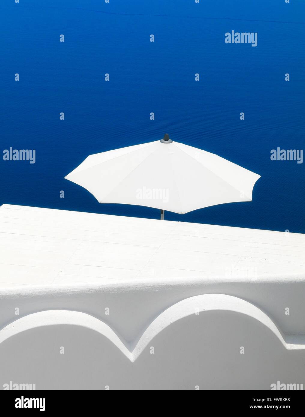A whitewashed building and sun brolly on the Island of Santorini Greece ...