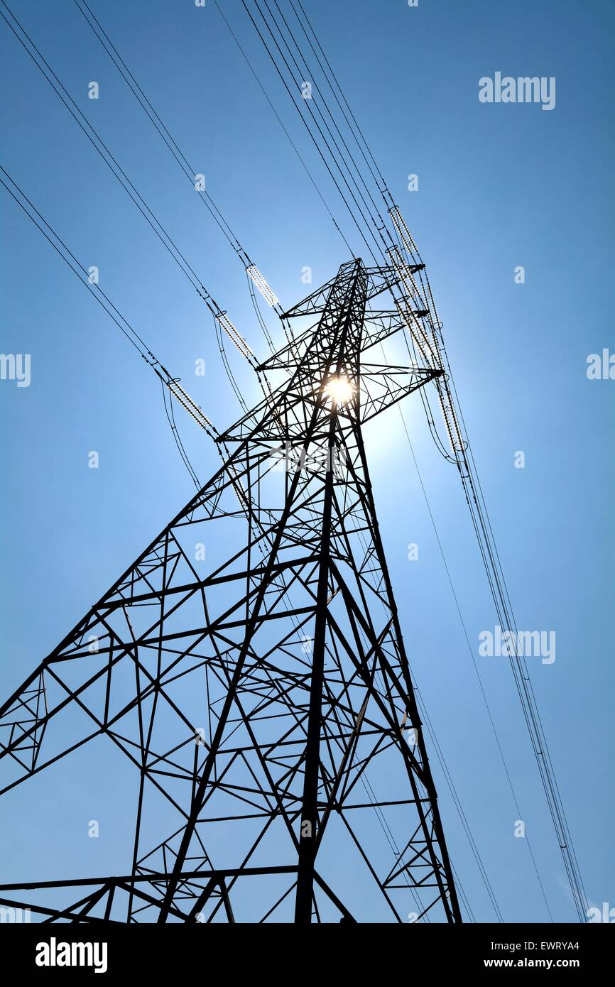 Low viewpoint of electricity pylon with sun bursting through Stock ...