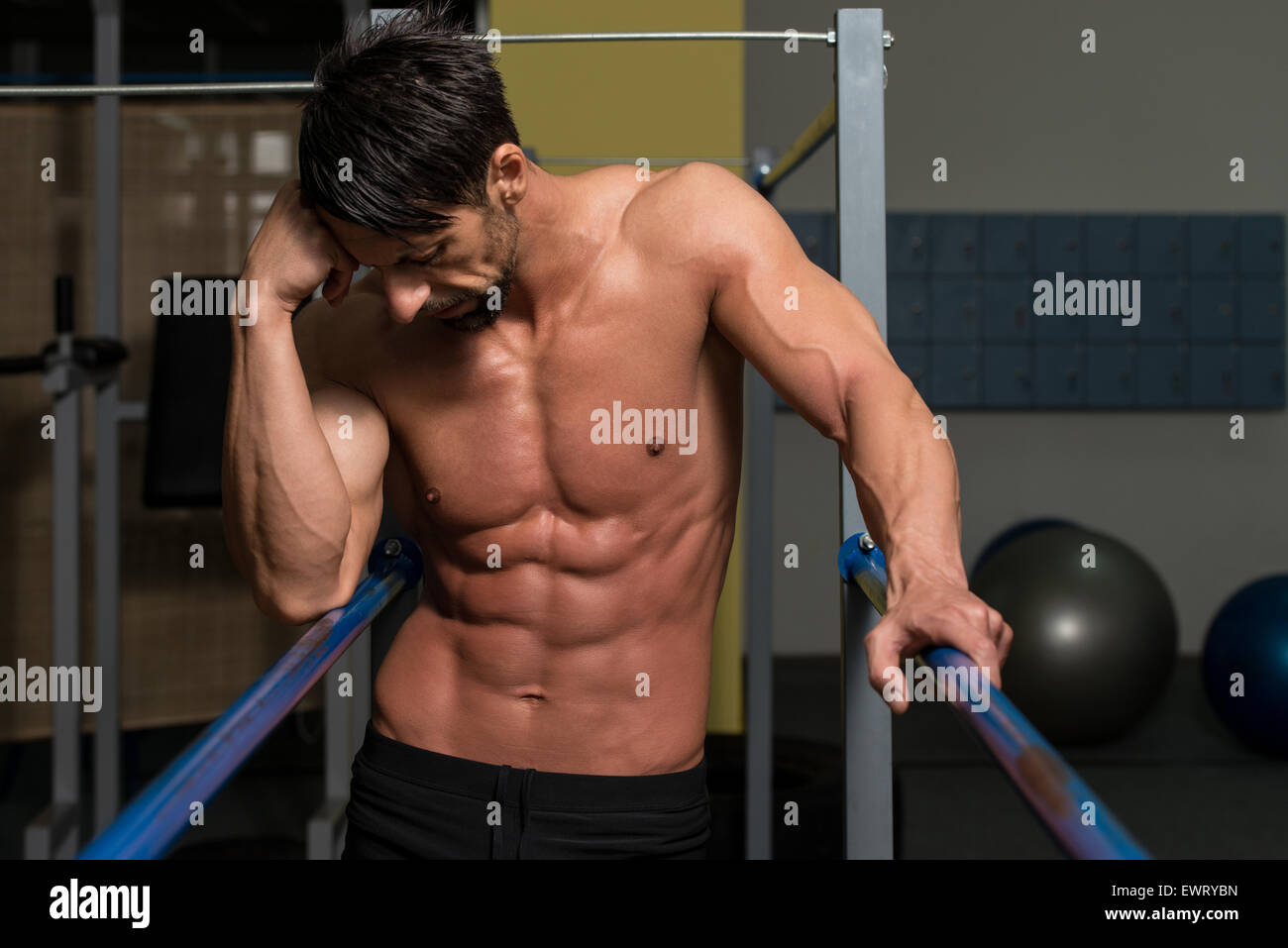 Fit Athlete Resting After Exercise On Parallel Bars Stock Photo - Alamy