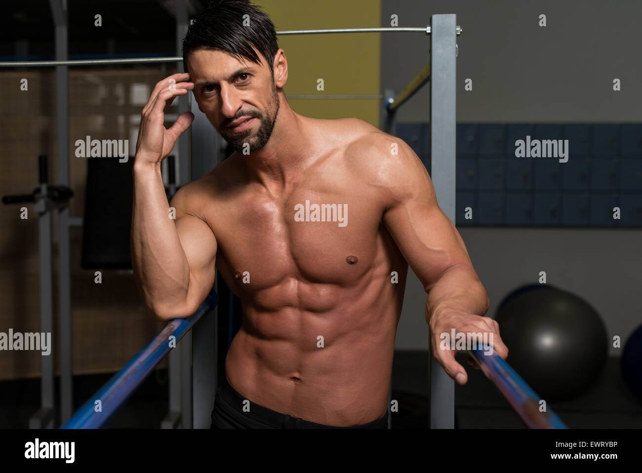 Fit Athlete Resting After Exercise On Parallel Bars Stock Photo - Alamy