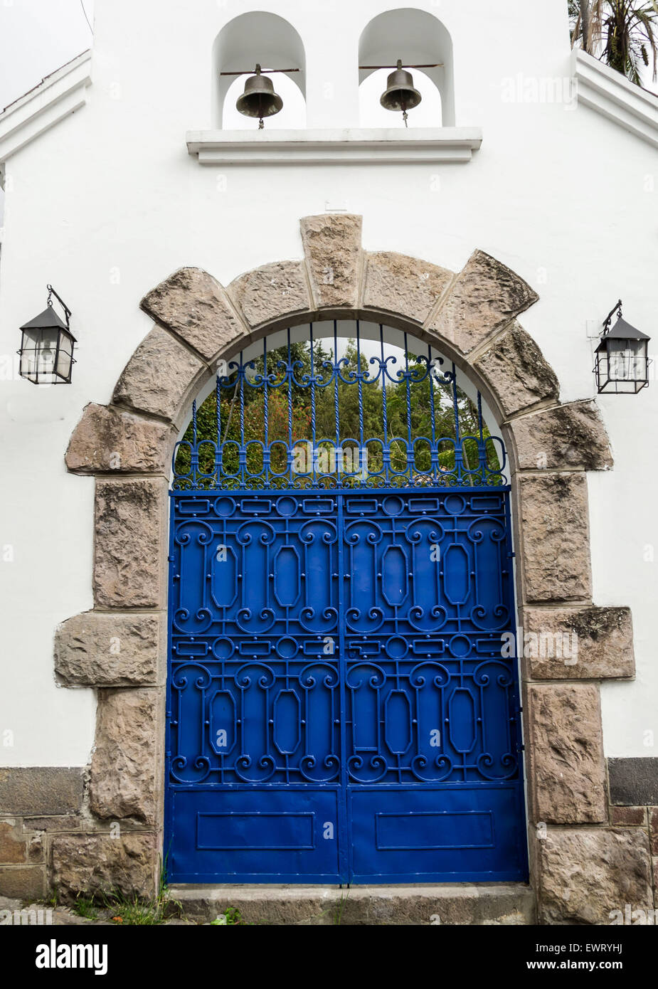 Artsy blue painted double gate with grey stones forming an arch on ...