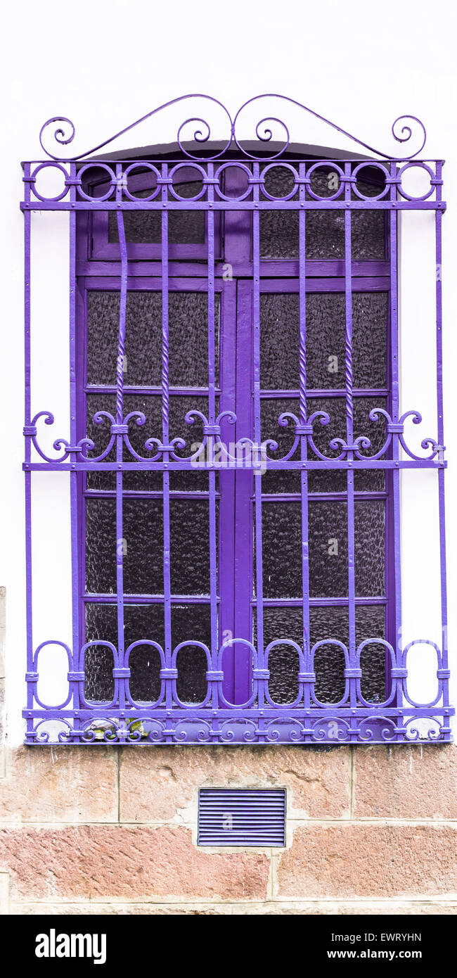 Purple colored window and metal bars on white concrete building Stock ...
