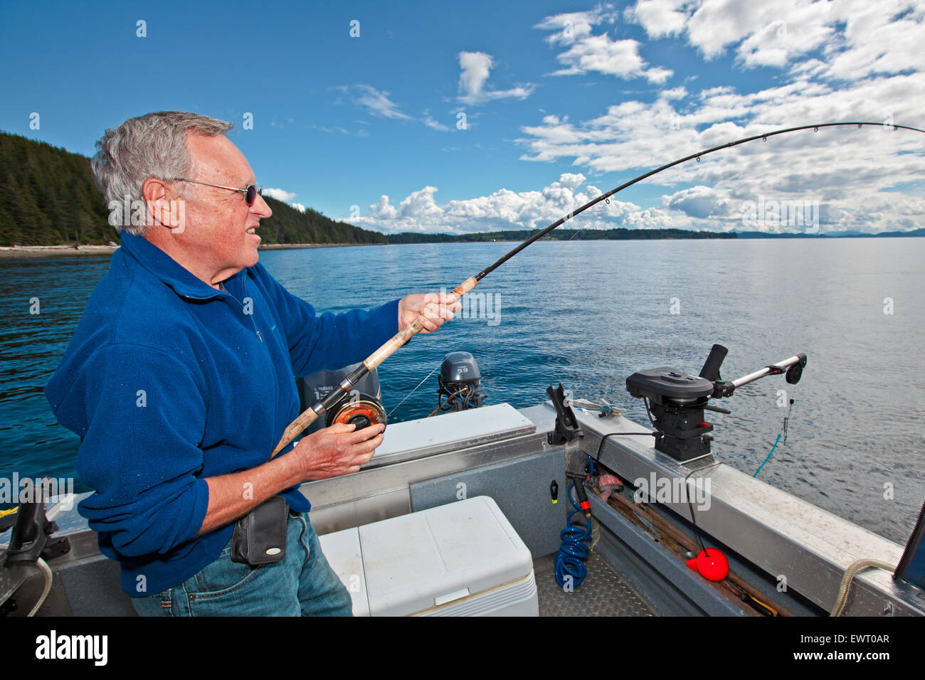 Senior retired man fishing with fishing rod in his hands off Northern ...