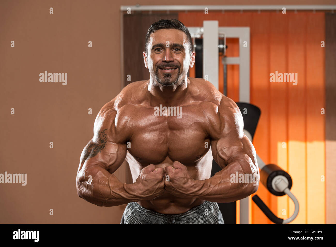 Bodybuilder Standing In The Gym And Flexing Muscles Stock Photo - Alamy