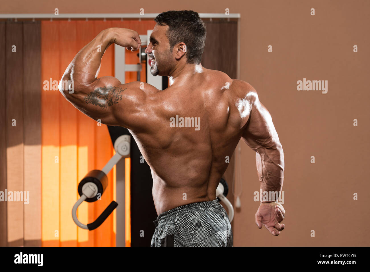 Bodybuilder Standing In The Gym And Flexing Muscles Stock Photo - Alamy