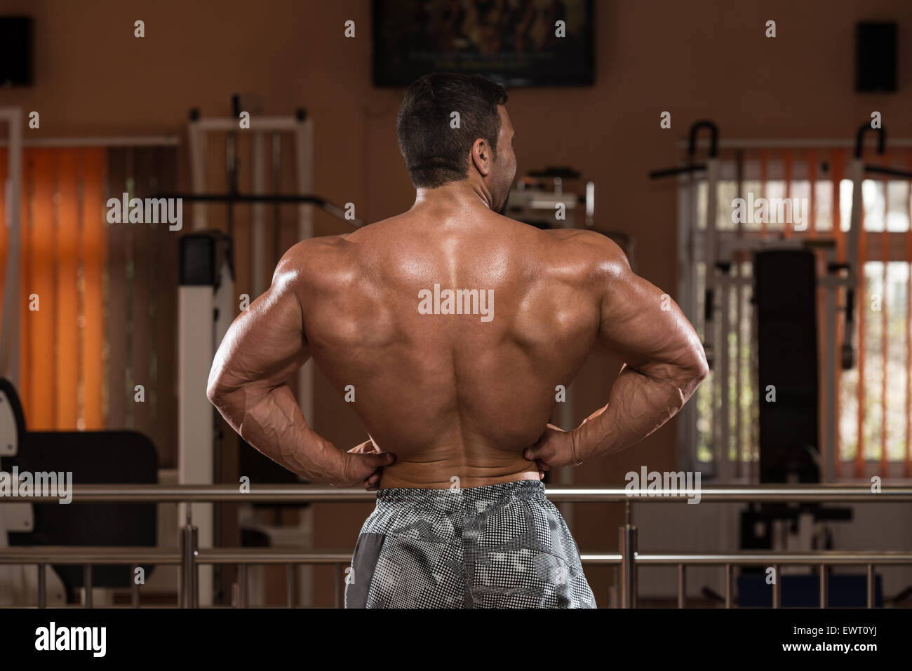 Bodybuilder Standing In The Gym And Flexing Muscles Stock Photo - Alamy