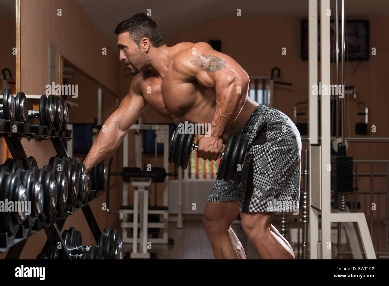 Mexican Bodybuilder Doing Heavy Weight Exercise For Back With Dumbbells ...