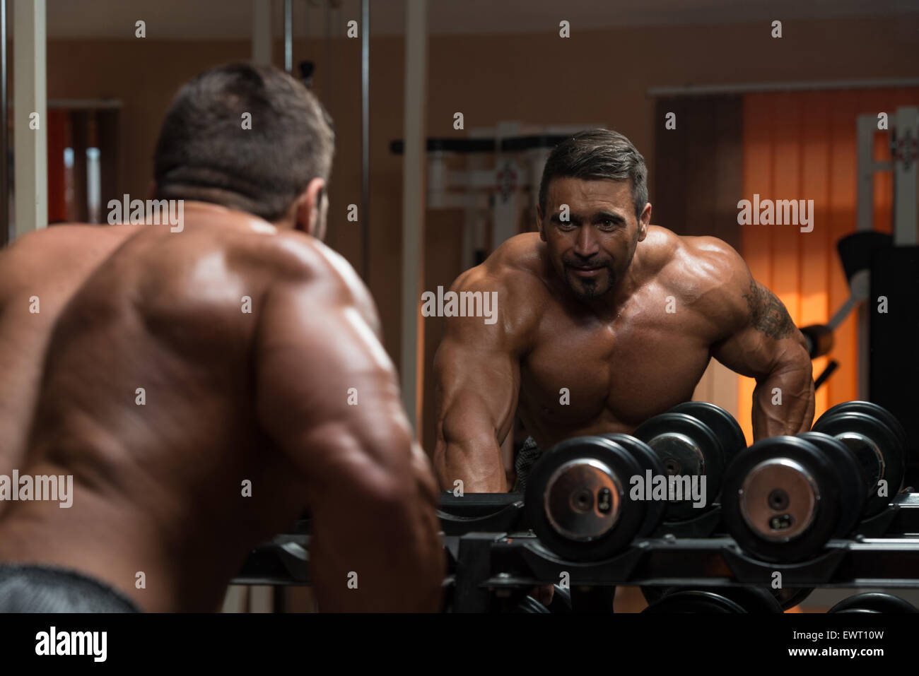 Mexican Bodybuilder Doing Heavy Weight Exercise For Back With Dumbbells ...