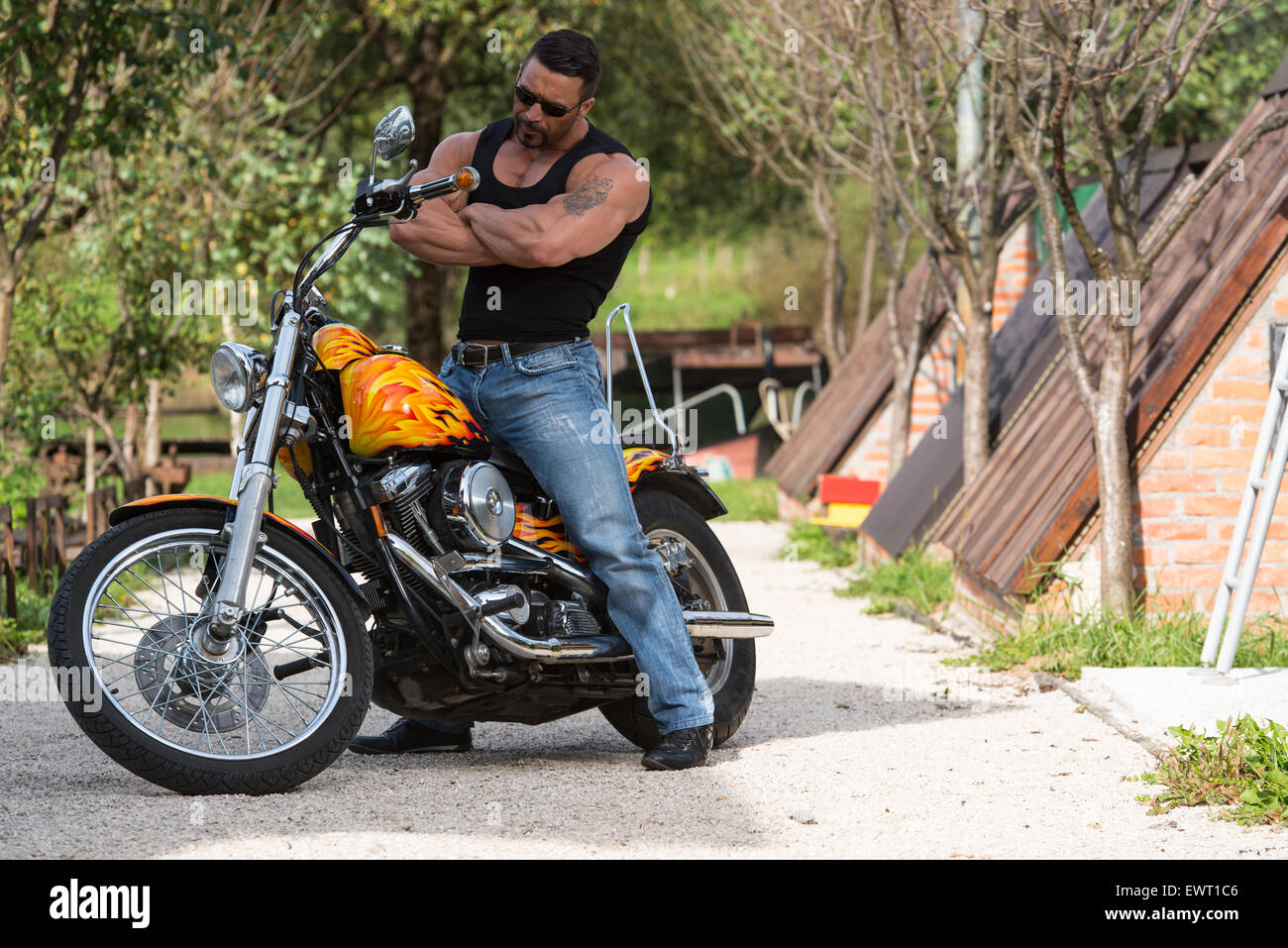 Biker Man Bodybuilder Sits On A Bike Stock Photo - Alamy