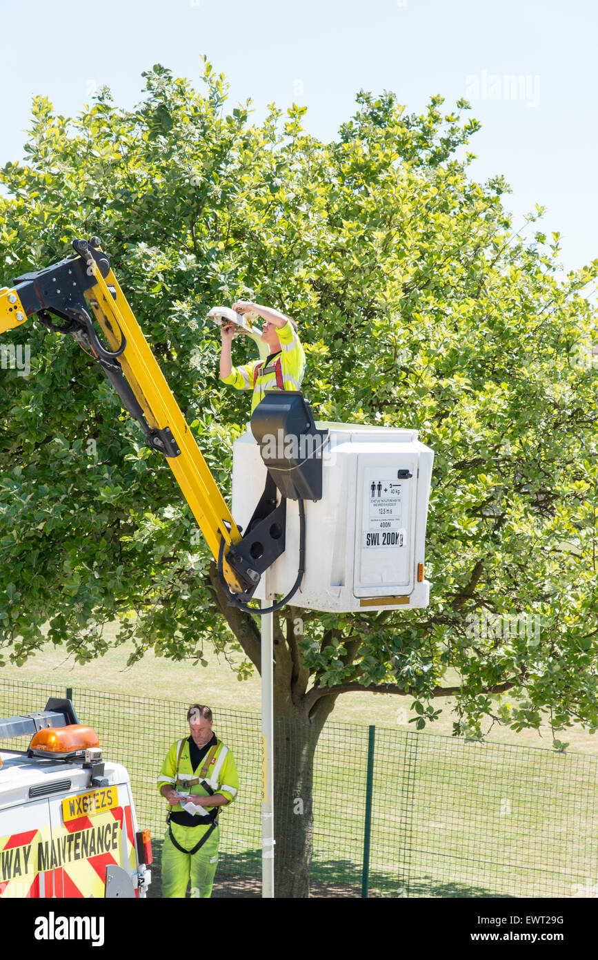 Cherry picker being used for traffic light maintenance in suburban ...