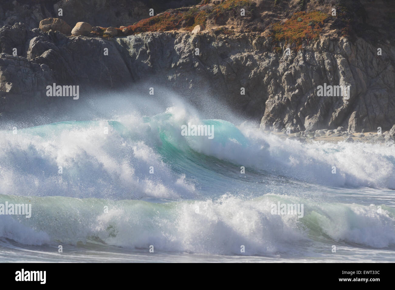 California coast landscape with large rocks and waves splashing with ...