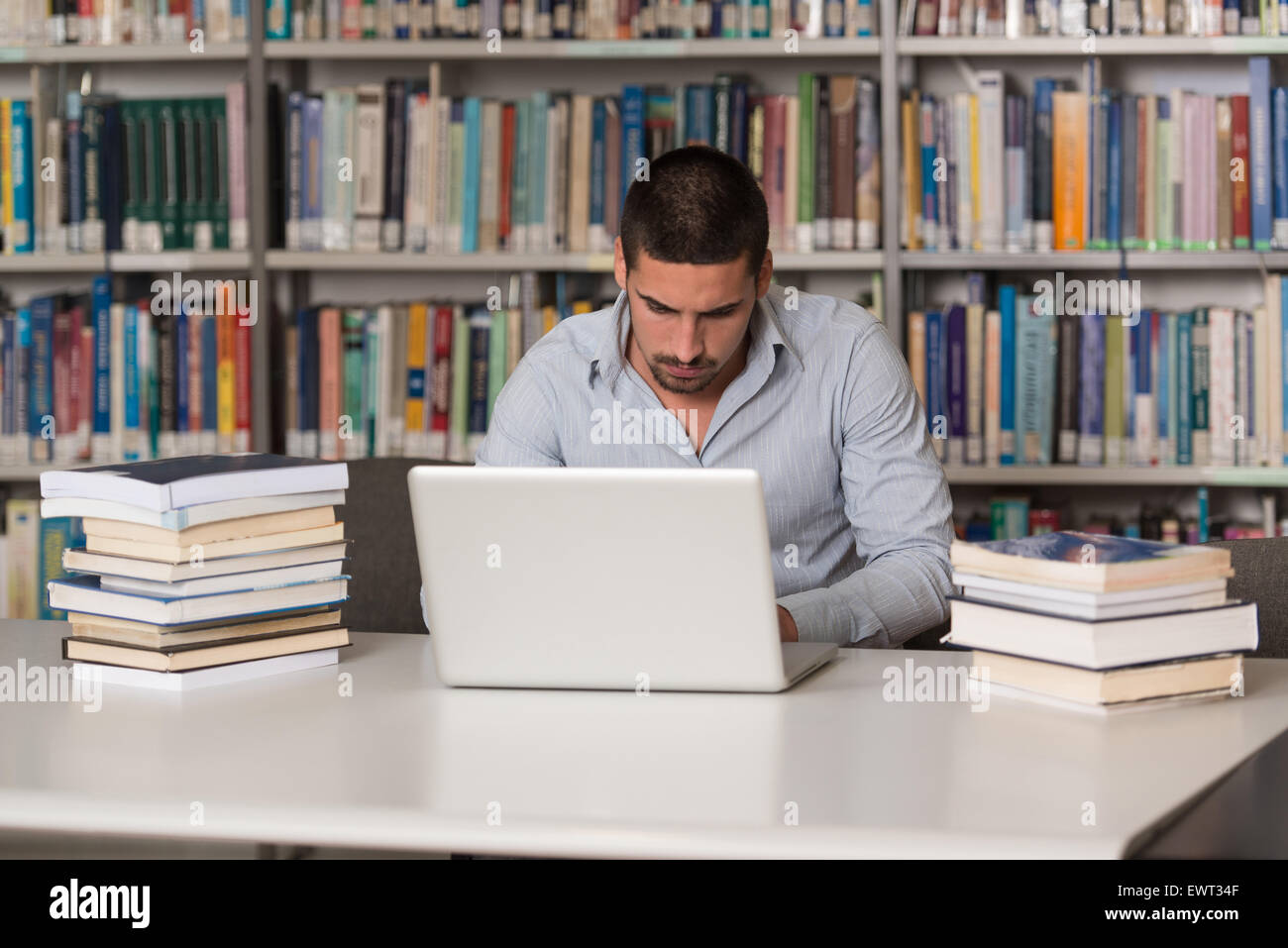 In The Library - Handsome Male Student With Laptop And Books Working In ...
