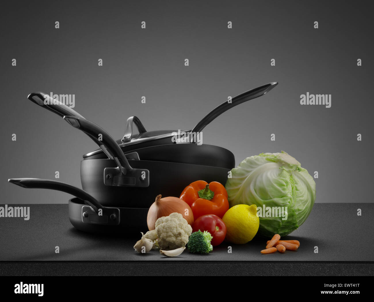 close up view of nice cookware set with some vegetables on grey back ...