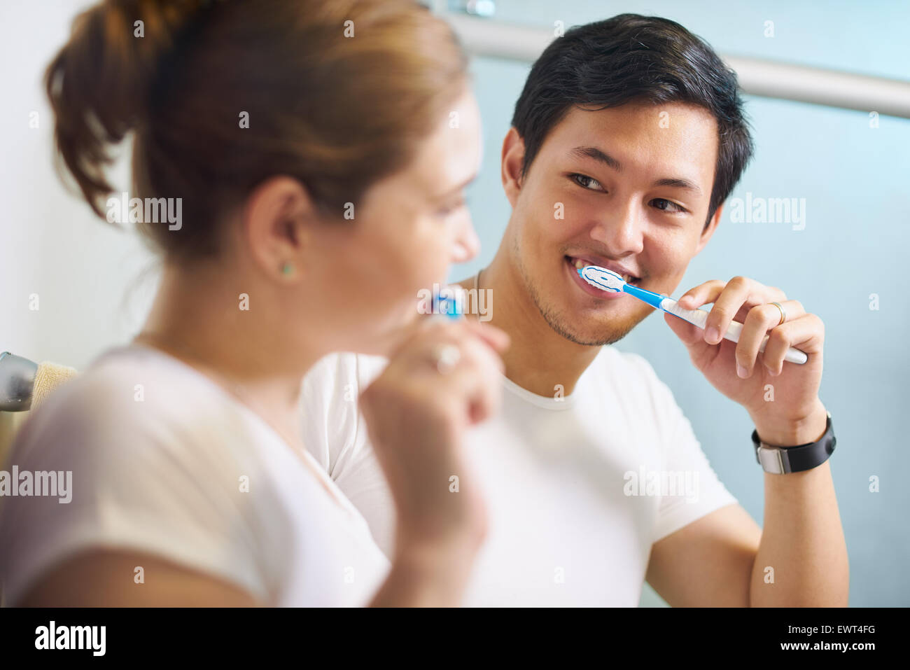 Young couple living together, washing teeth in bathroom in the morning ...