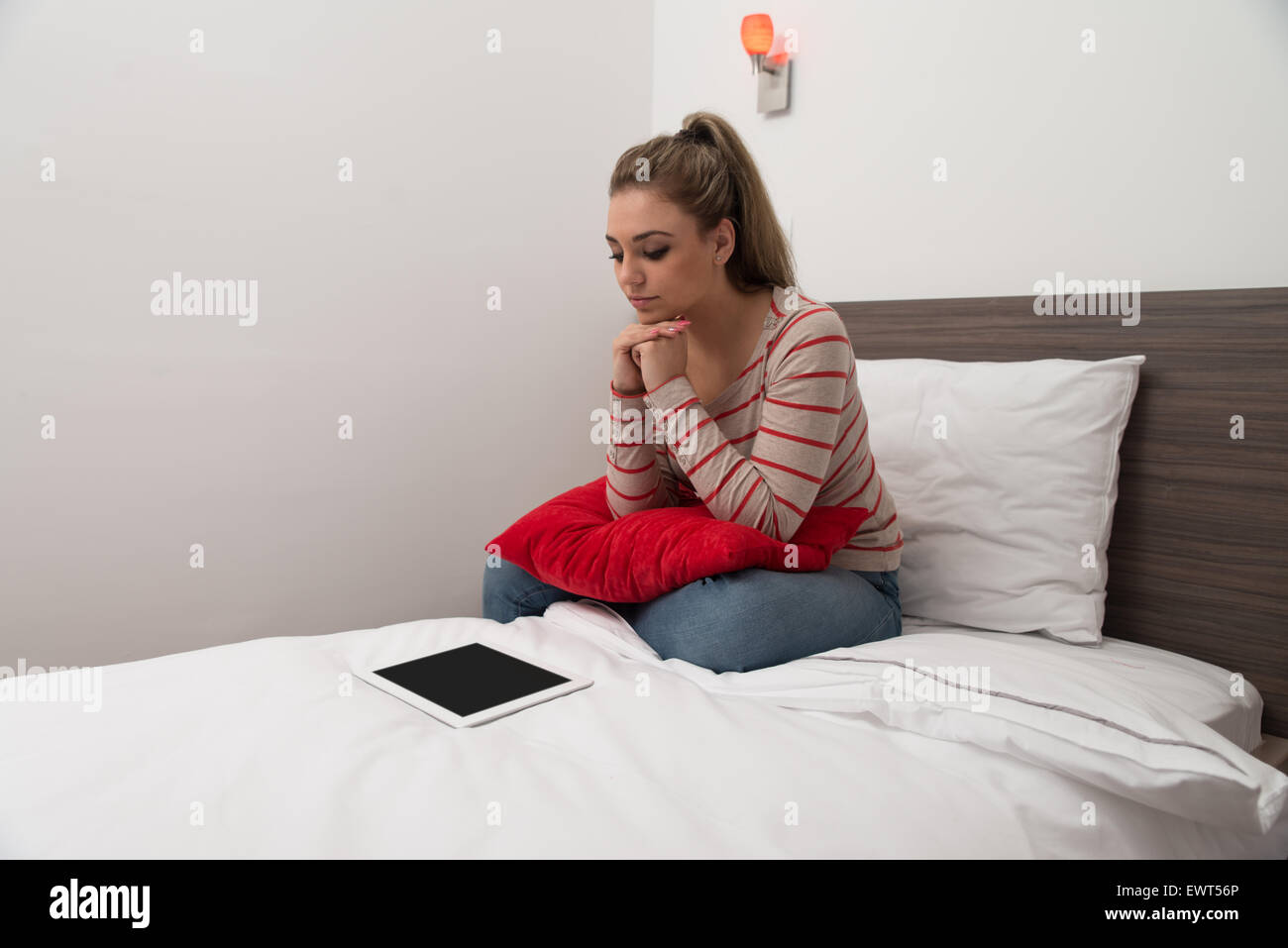 Young Female Student Lying On Bed And Having Fun With Touch Pad In ...