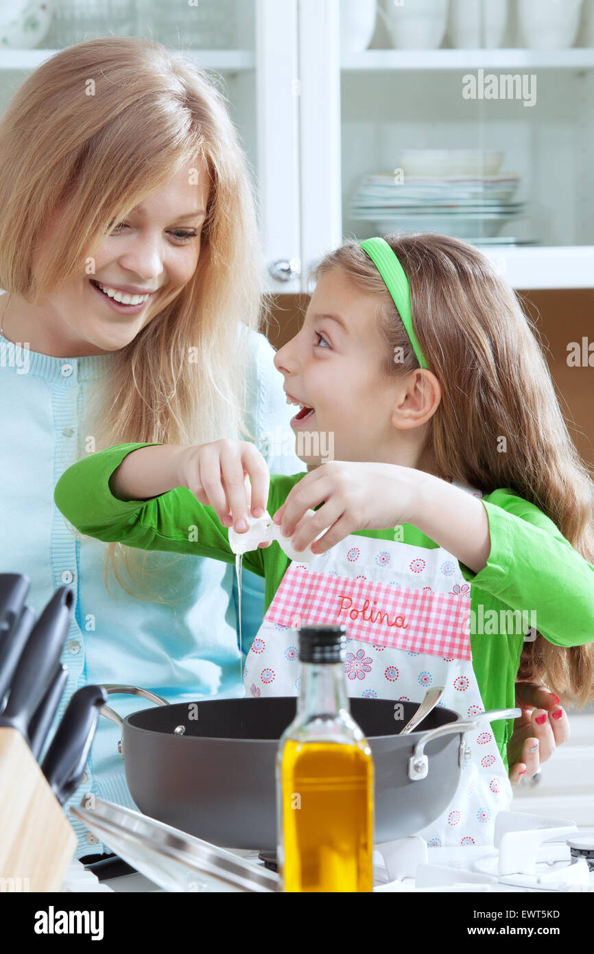view of young beautiful girl cooking at the kitchen with her mama Stock ...