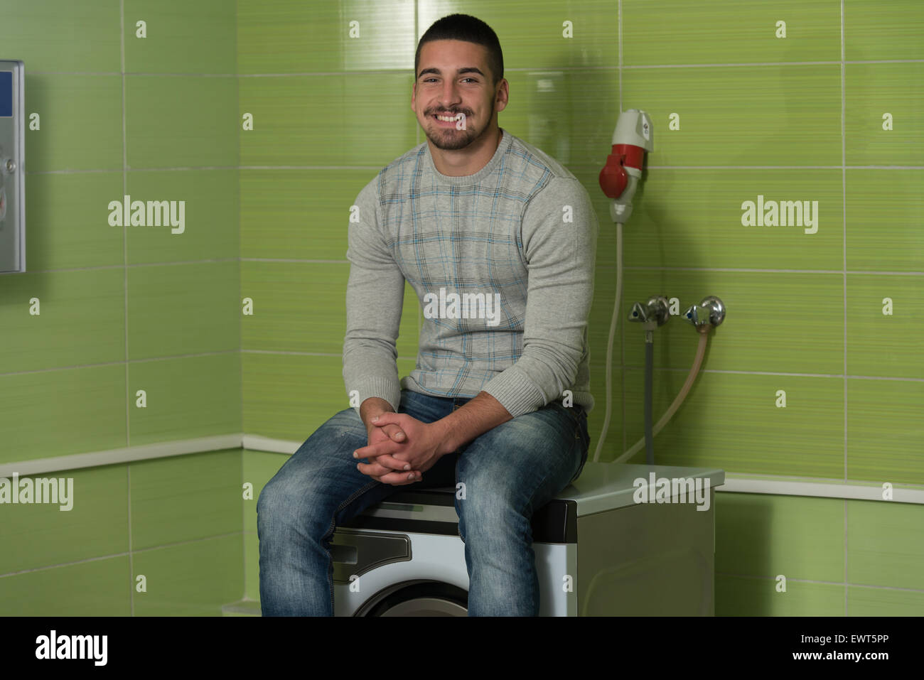 Handsome Young Man In The Laundry Room Stock Photo - Alamy
