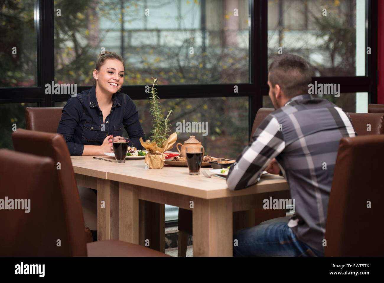 Friends Eating At A Restaurant And Looking Happy Stock Photo - Alamy