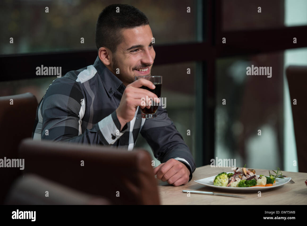 Handsome Man Eating At A Restaurant And Looking Happy Stock Photo - Alamy