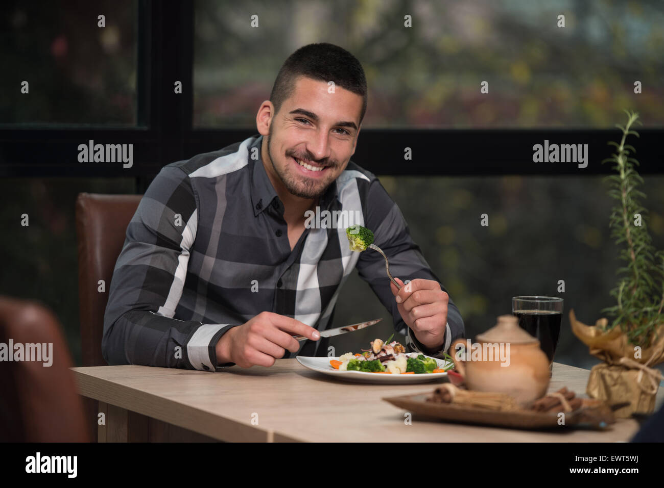 Handsome Man Eating At A Restaurant And Looking Happy Stock Photo - Alamy