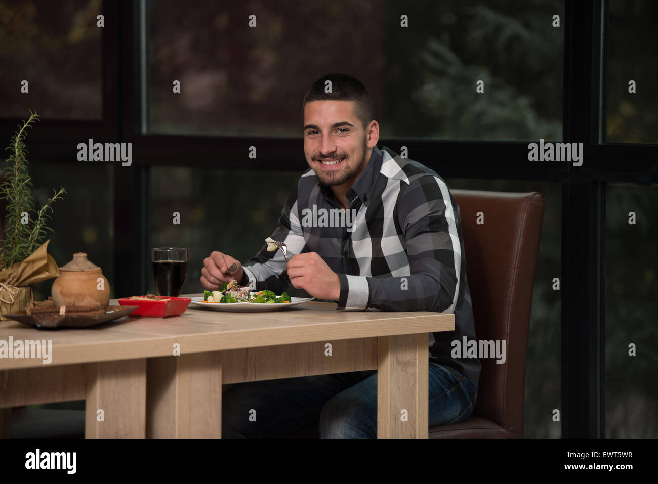 Handsome Man Eating At A Restaurant And Looking Happy Stock Photo - Alamy