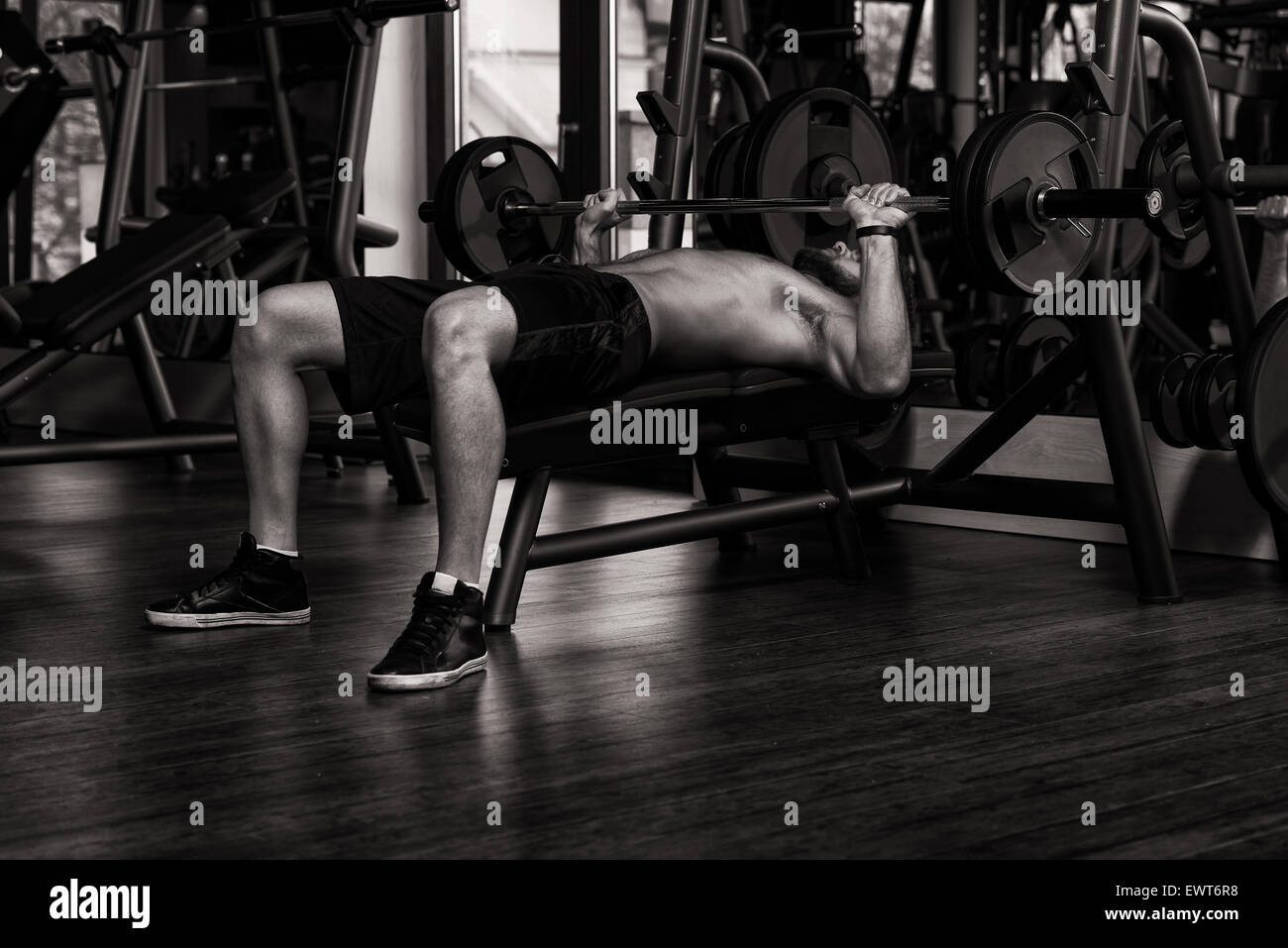 Handsome Man Is Working Out Chest With Barbell In A Modern Gym Stock ...