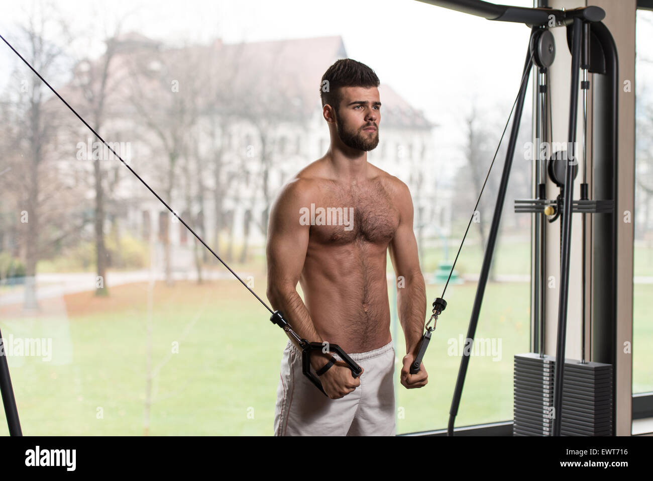 Handsome Man Is Working On His Chest With Cable Crossover In A Modern ...