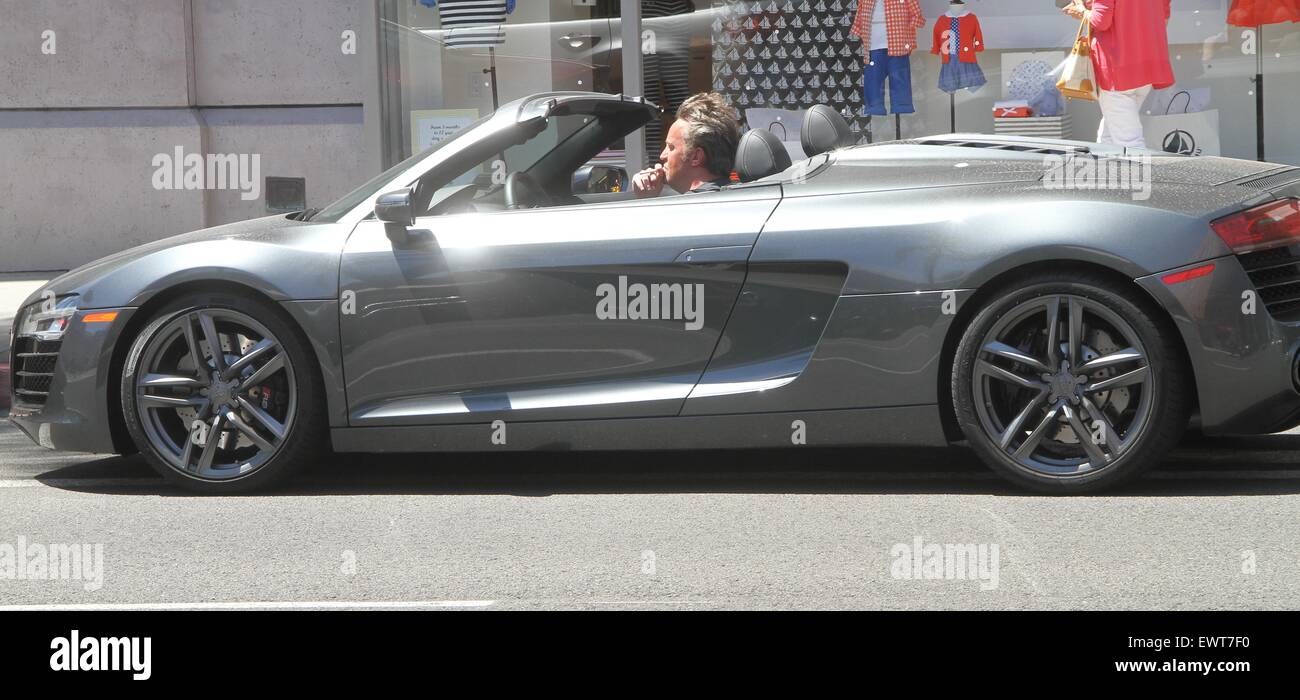 Matthew Perry with his hair swept back, smokes a cigarette while ...