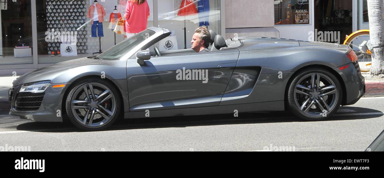 Matthew Perry with his hair swept back, smokes a cigarette while ...