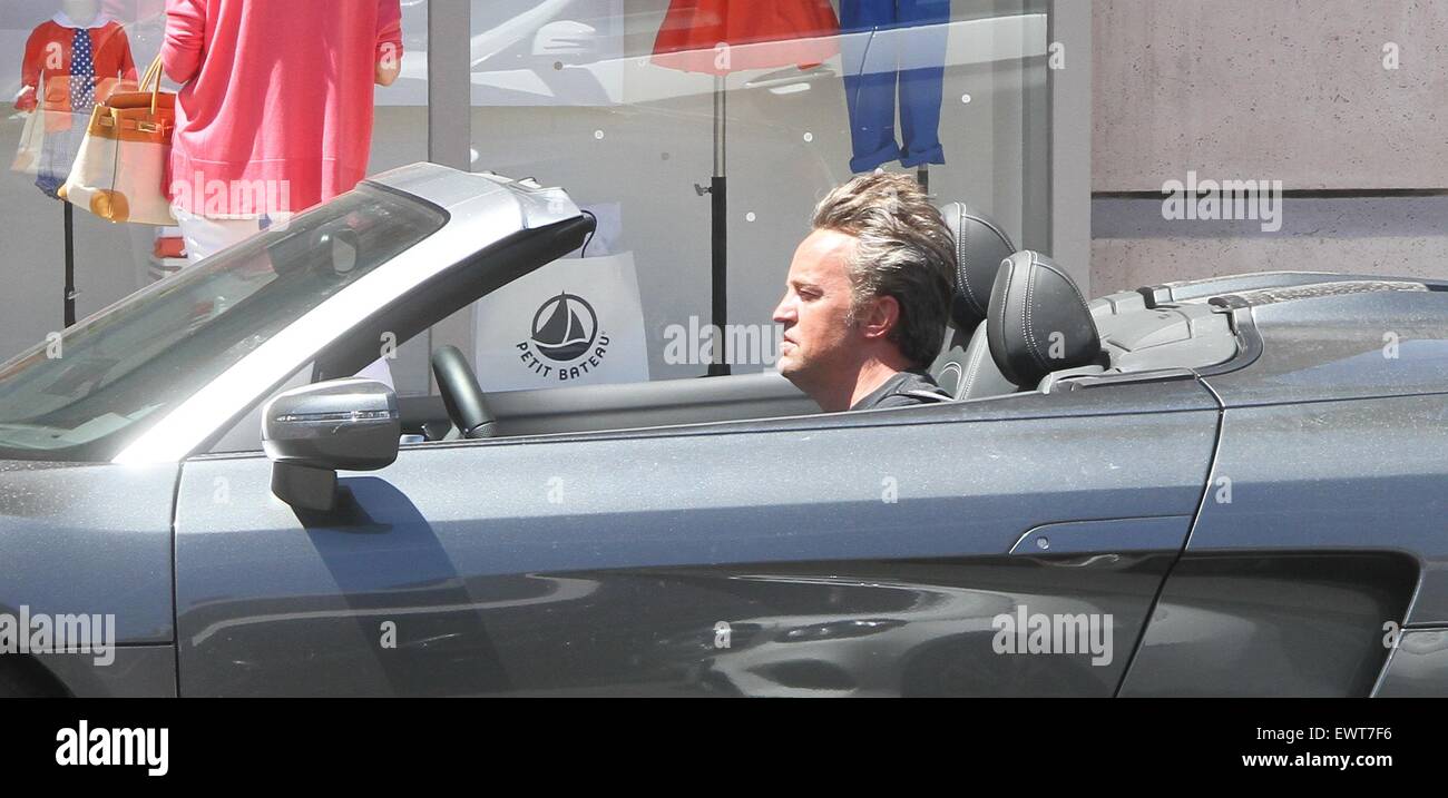 Matthew Perry with his hair swept back, smokes a cigarette while ...