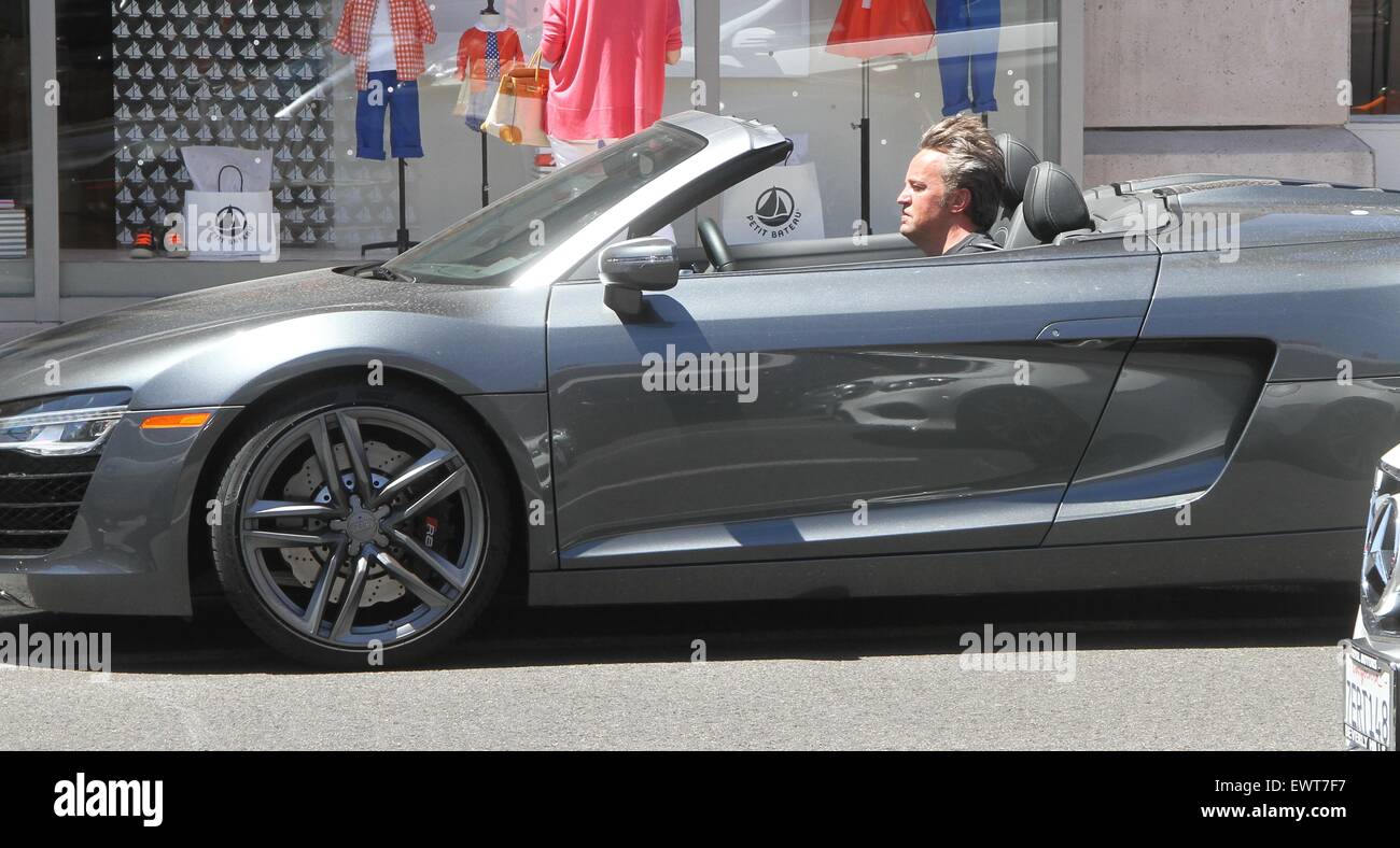 Matthew Perry with his hair swept back, smokes a cigarette while ...