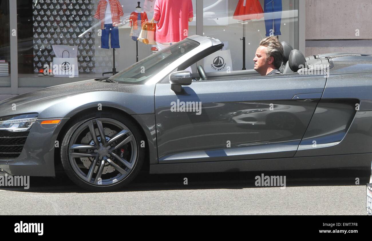 Matthew Perry with his hair swept back, smokes a cigarette while ...