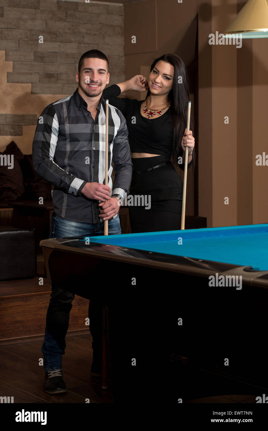 Portrait Of A Young Couple Playing Billiards Stock Photo - Alamy