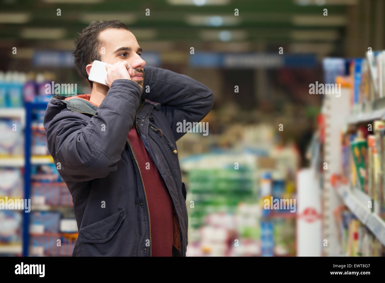 Smiling Young Man Using Mobile Phone While Shopping In Shopping Store ...