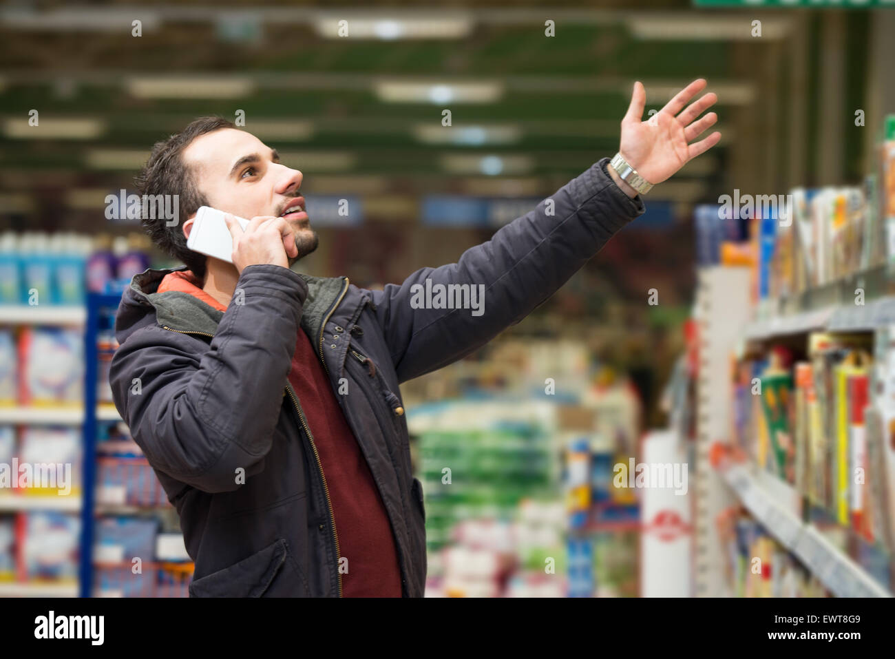 Smiling Young Man Using Mobile Phone While Shopping In Shopping Store ...