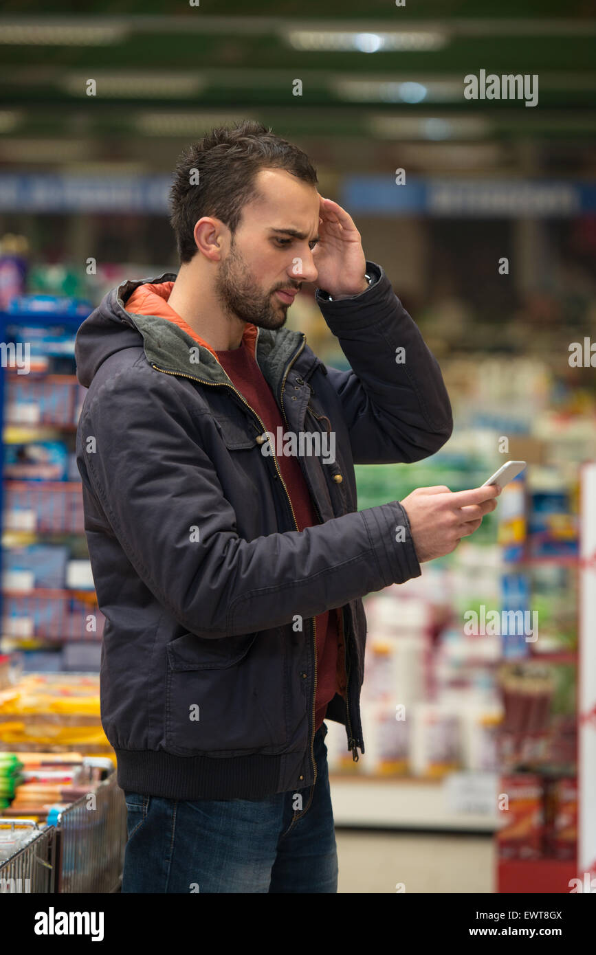 Smiling Young Man Using Mobile Phone While Shopping In Shopping Store ...